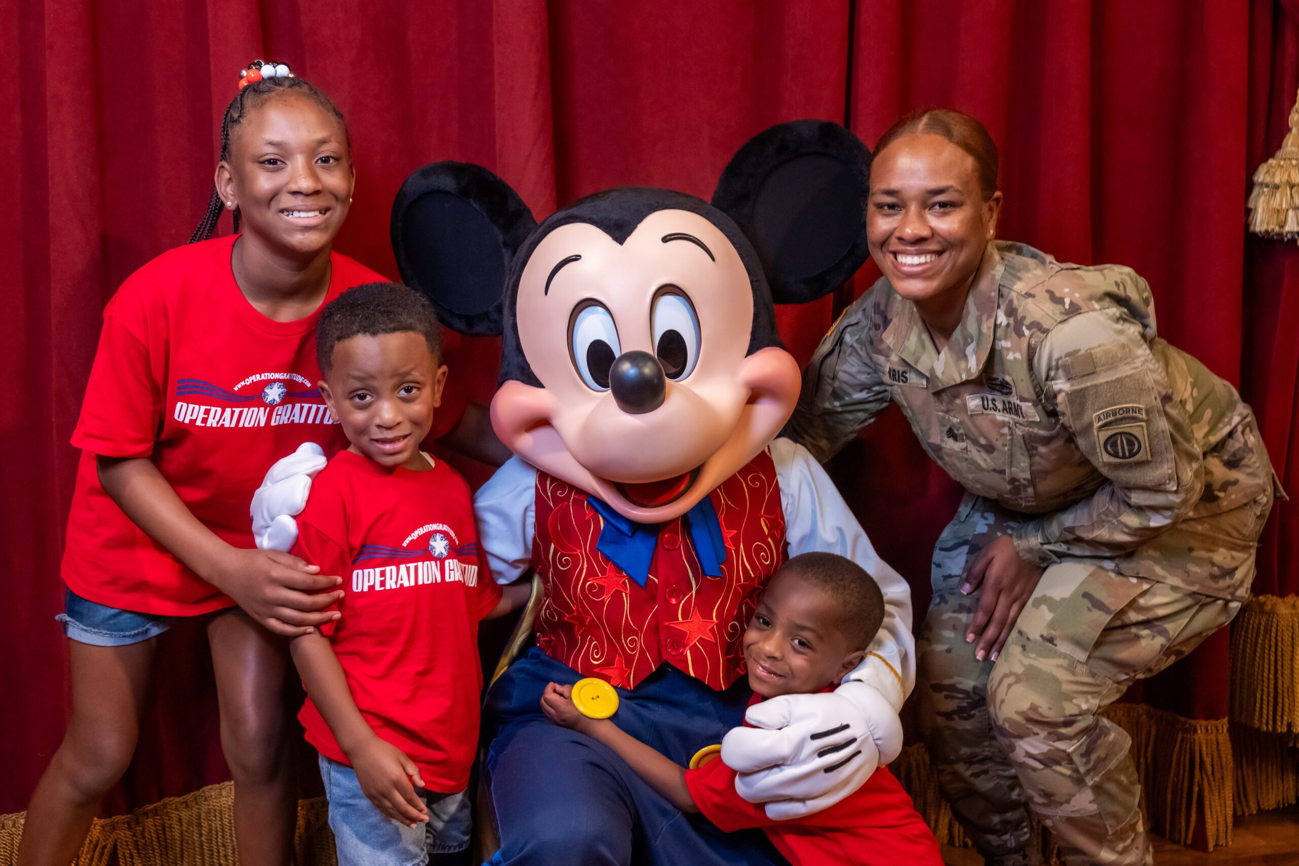 Sgt. Harris and her children pose with Mickey Mouse at The Town Square ...